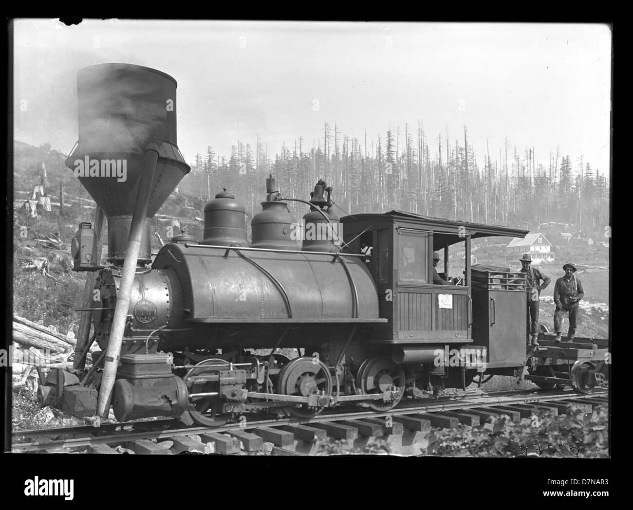 The image shows a steam engine and several men, likely involved in a ...