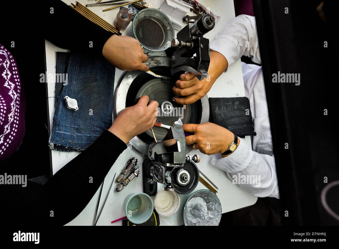 Emerald cutters polish gemstones on a faceting machine in a cutting and ...