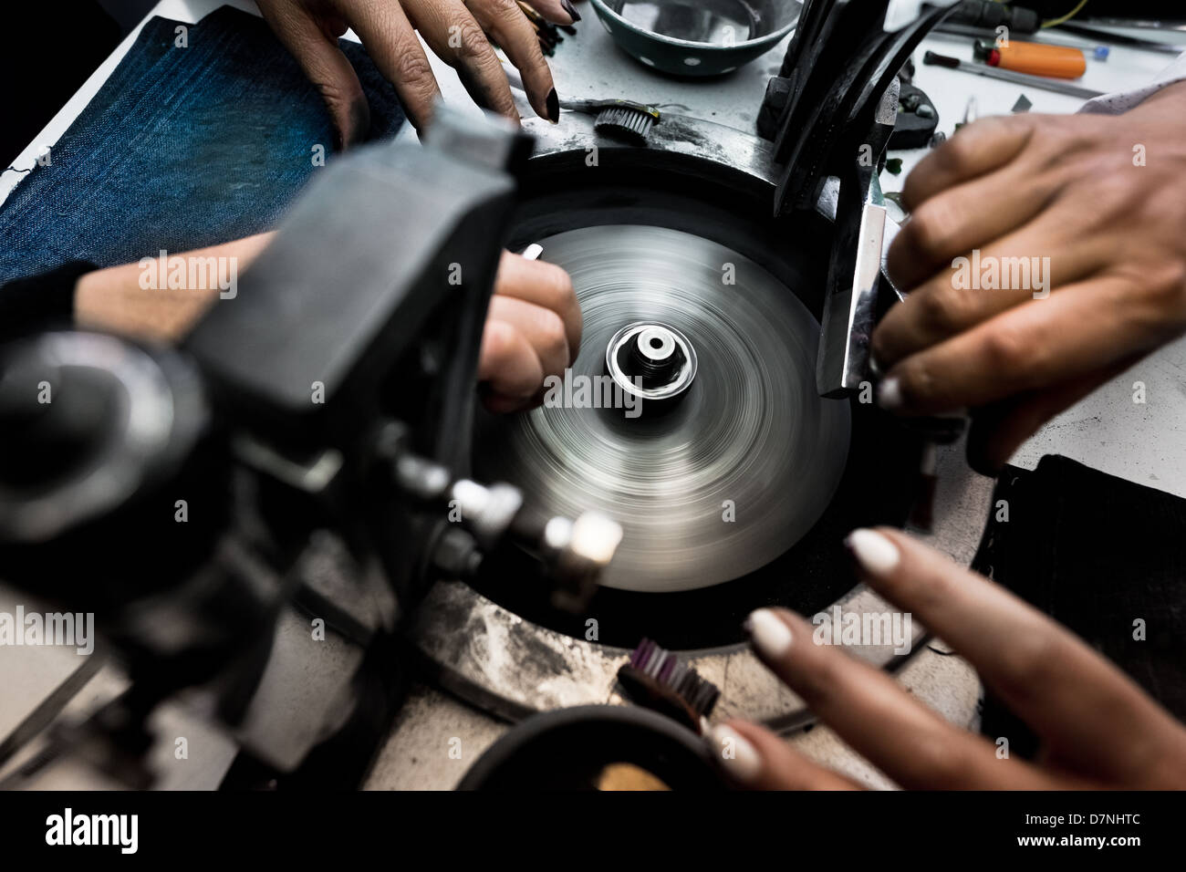 Emerald cutters polish gemstones on a faceting machine in a cutting and ...