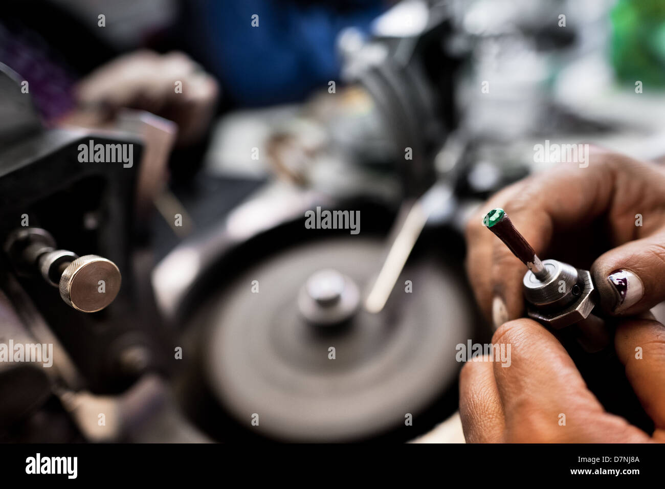 An emerald cutter checks out a gemstone she is working on in a cutting ...