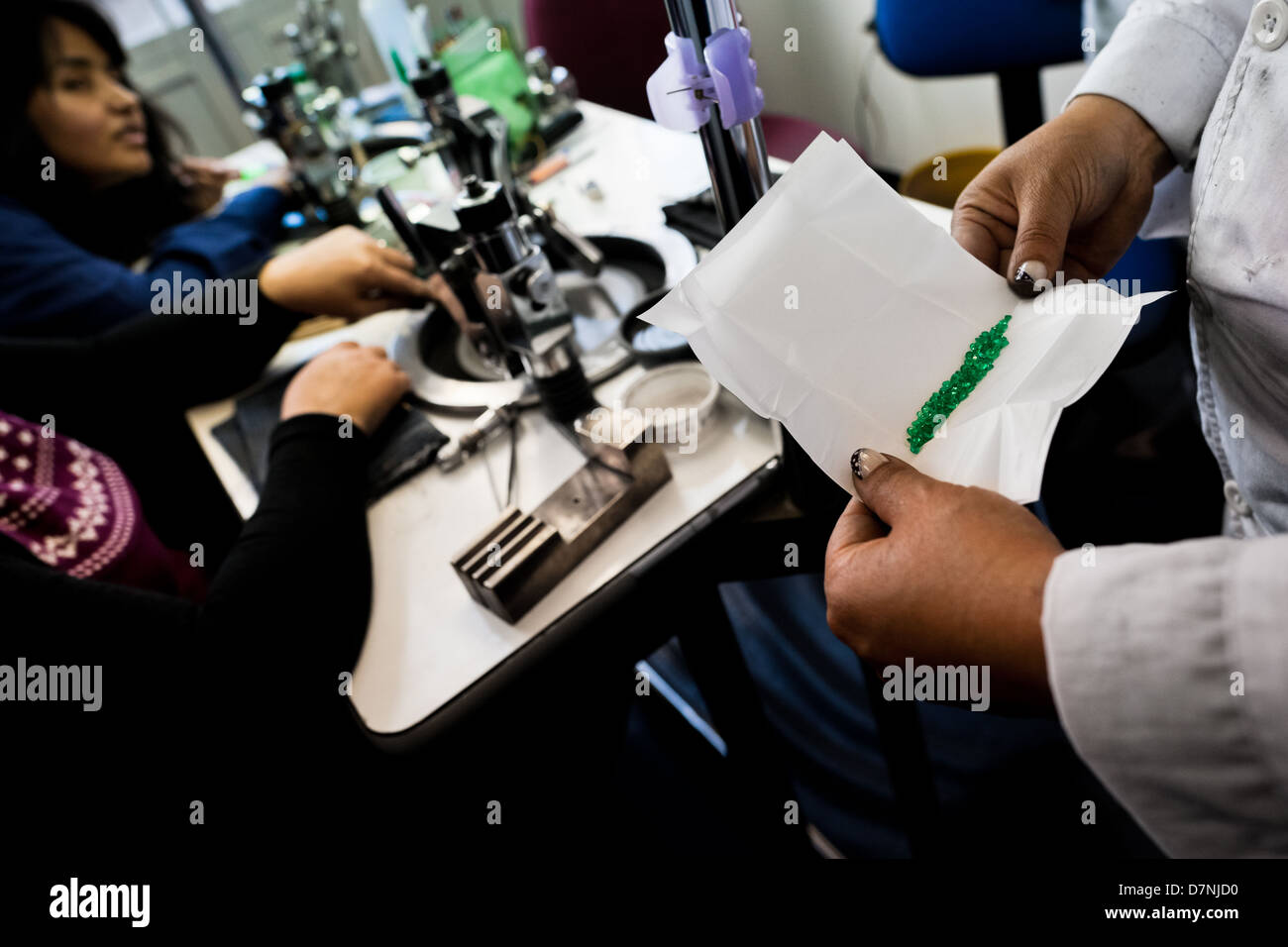 An emerald cutter shows fine emeralds after being processed in a ...