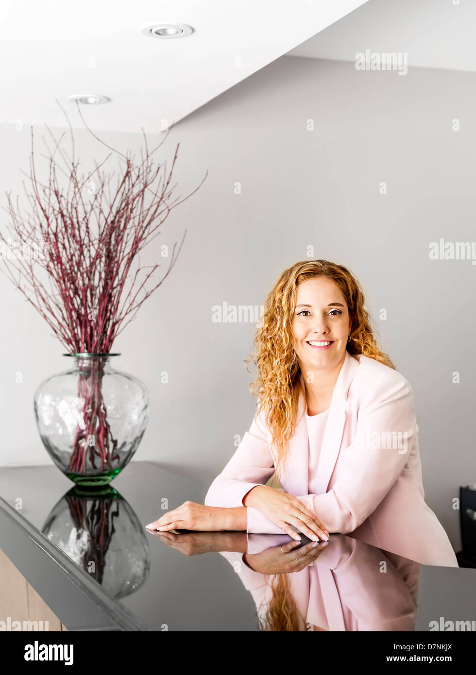 Receptionist standing at reception counter in office Stock Photo - Alamy