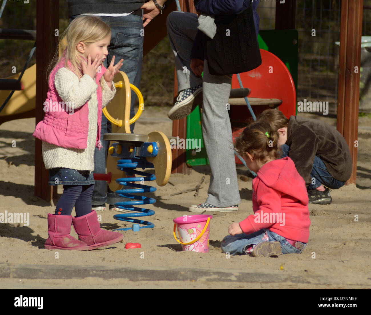 Two 4 year old little girl playing in the sand at playground in ...