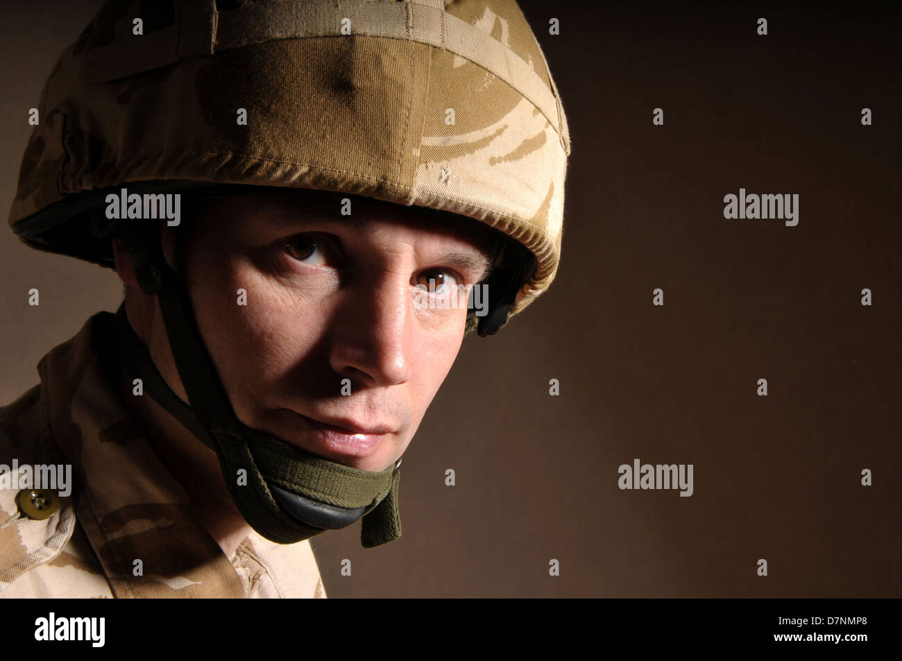 Portrait of a soldier with blank expression on his face against a dark ...