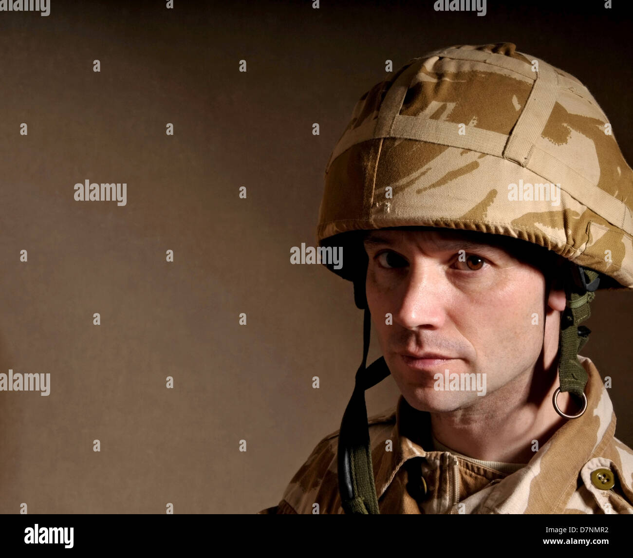 Portrait of a soldier with blank expression on his face against a dark ...