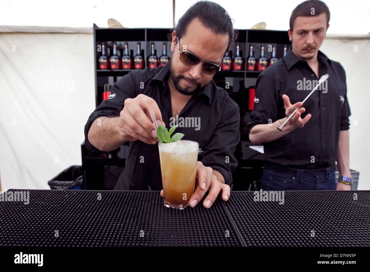 BARMAN/ BARTENDER PREPARES AND MAKES FINISHING TOUCH TO A COCKTAIL AT ...