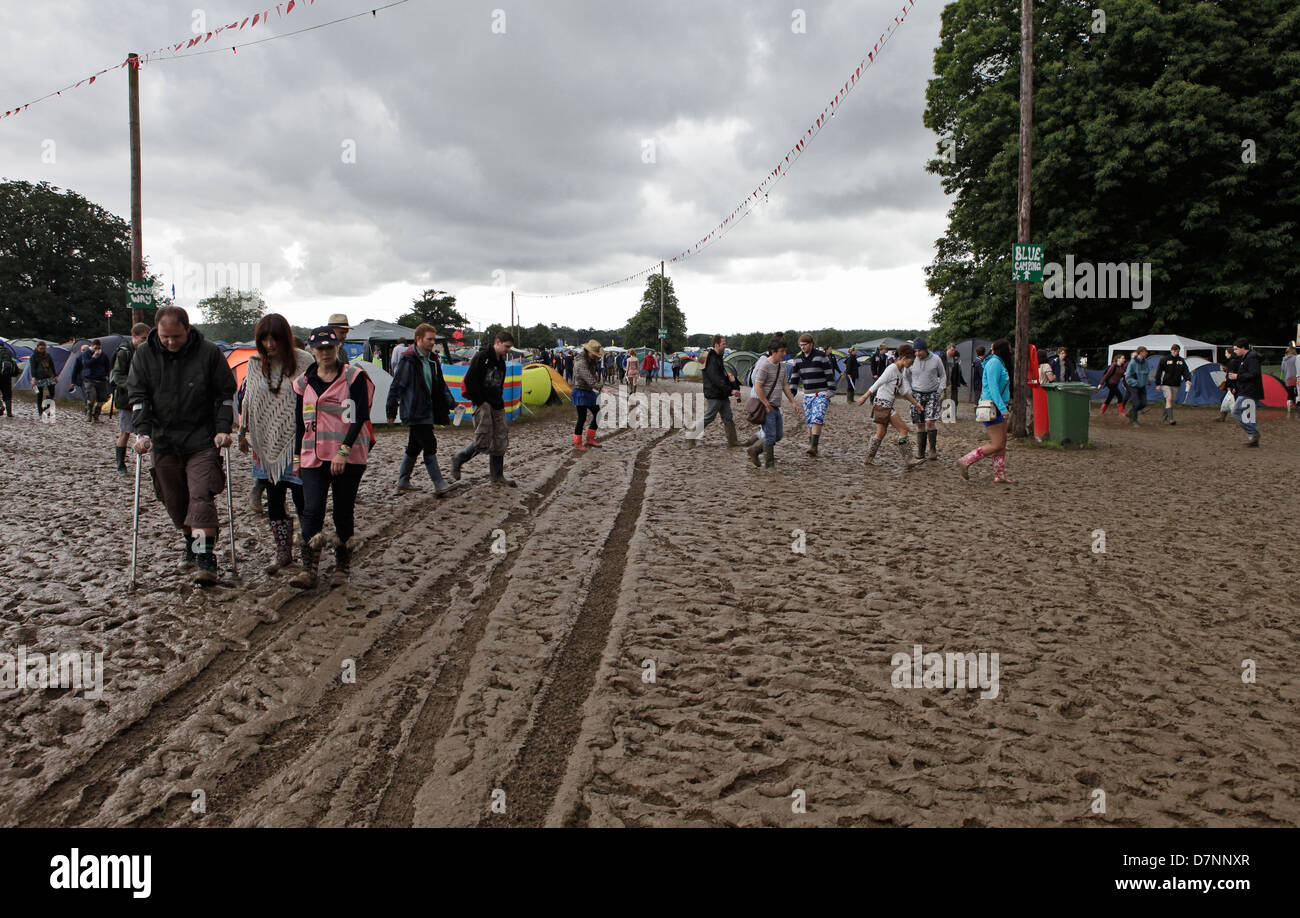 FESTIVALGOERS/ FESTIVAL GOERS WALKING THROUGH MUD AND PUDDLES IN WET ...