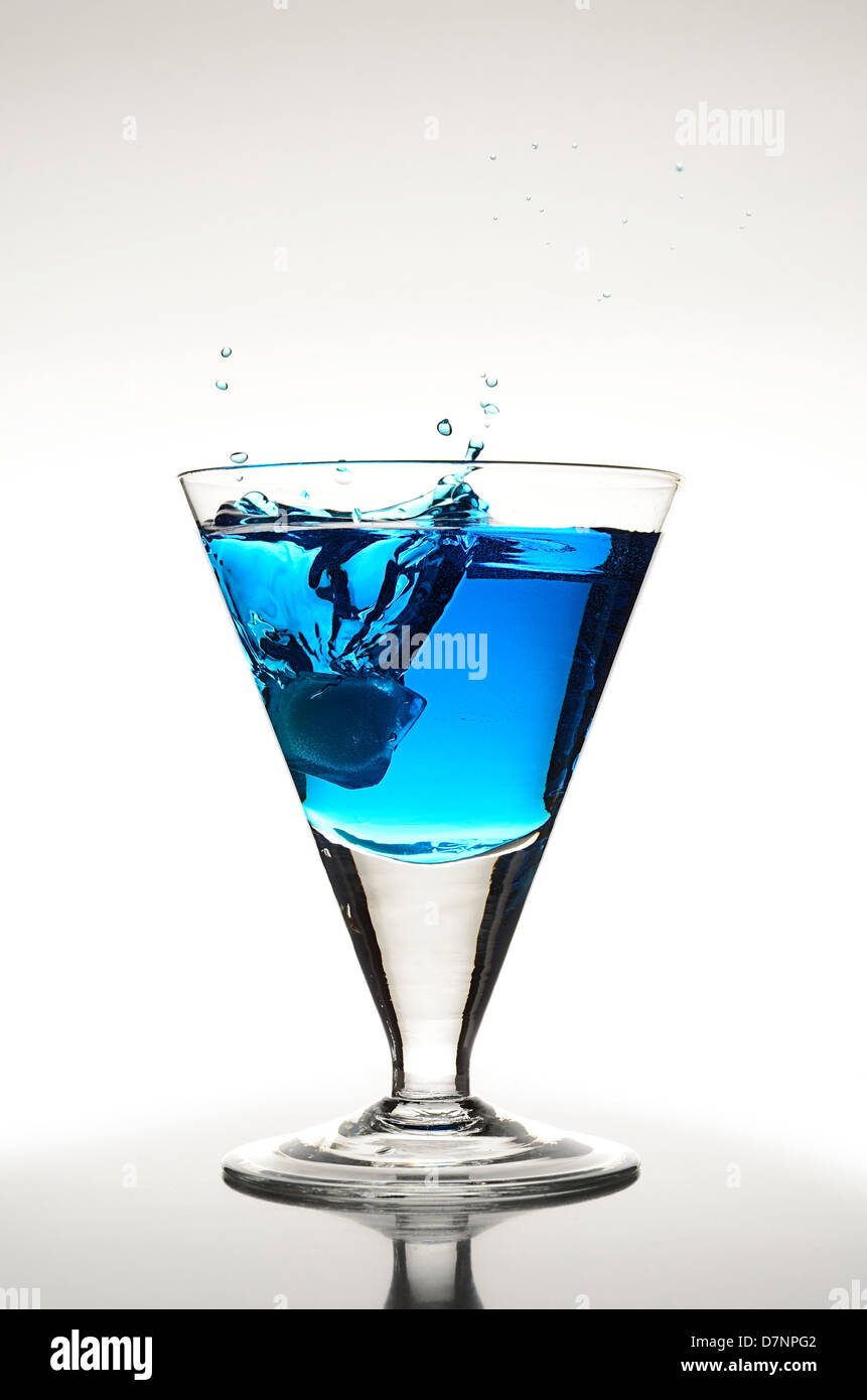 Blue cocktail with an ice cube and a big splash Stock Photo - Alamy