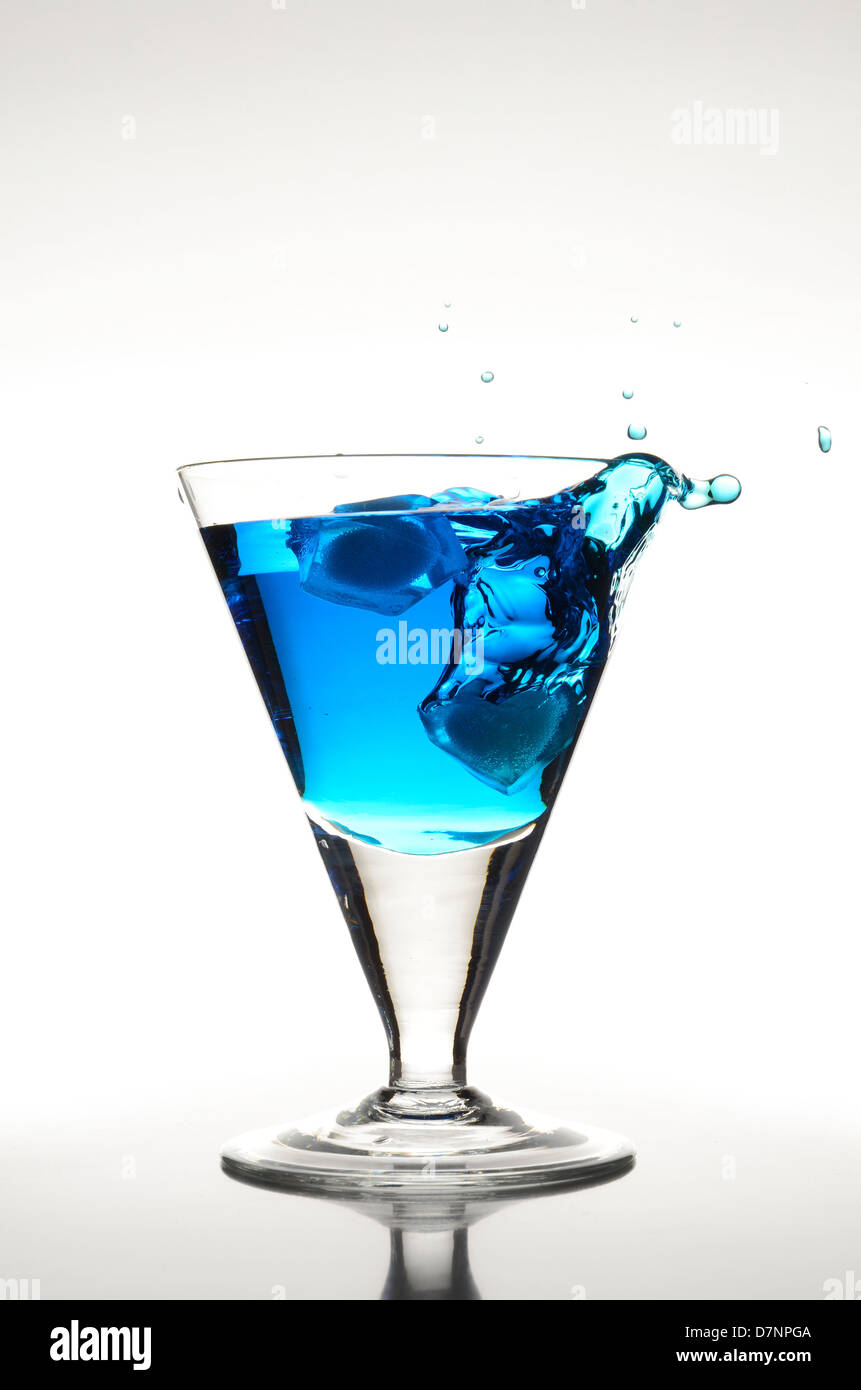 Blue cocktail with an ice cube and a big splash Stock Photo - Alamy