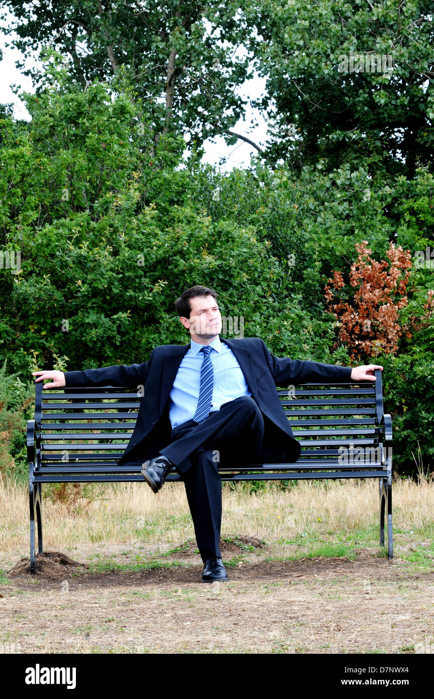 Businessman relaxing on park bench Stock Photo - Alamy