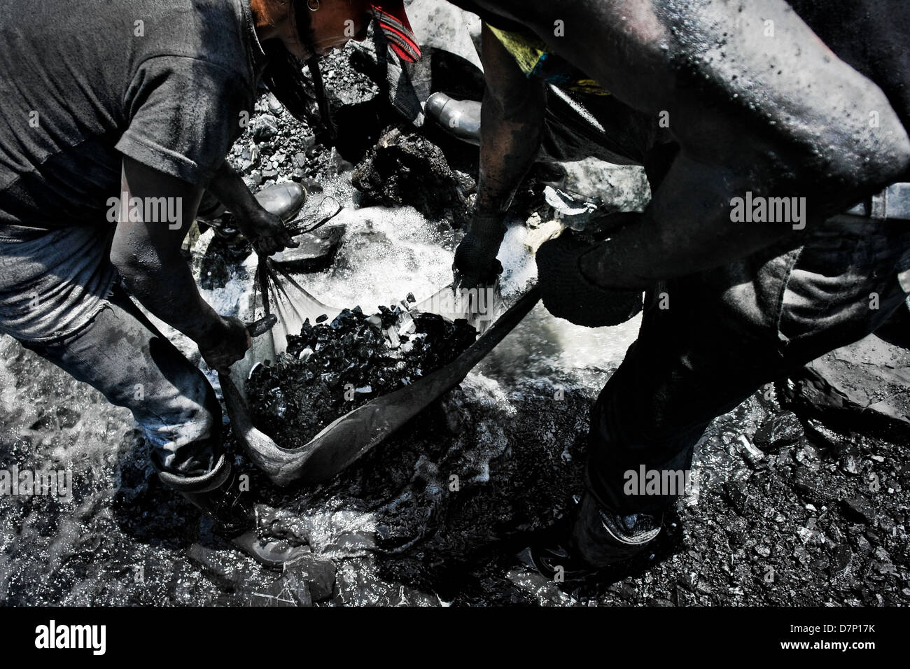 Miners wash the emerald containing mud in the mine in Muzo, Colombia ...