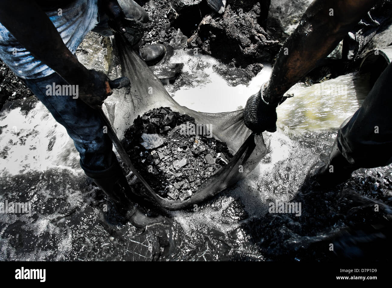 Miners wash the emerald containing mud in the mine of Muzo, Colombia ...