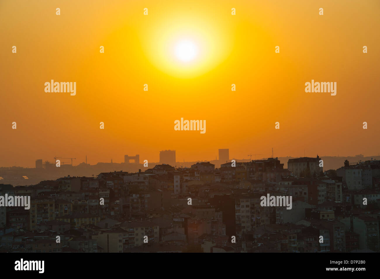 Orange sunset over a cityscape showing silhouette skyline of Istanbul ...