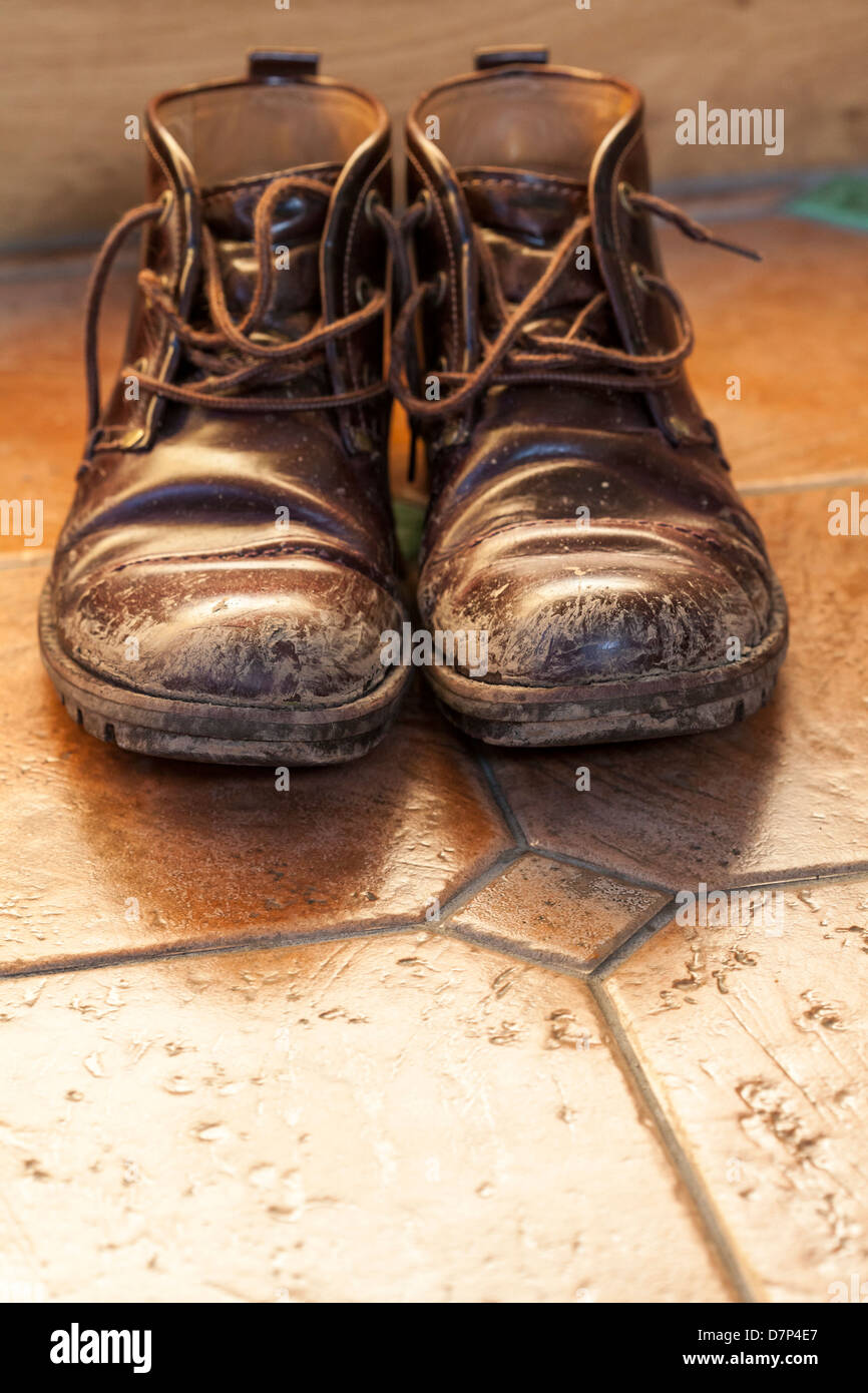 Muddy boots on tiled floor Stock Photo - Alamy