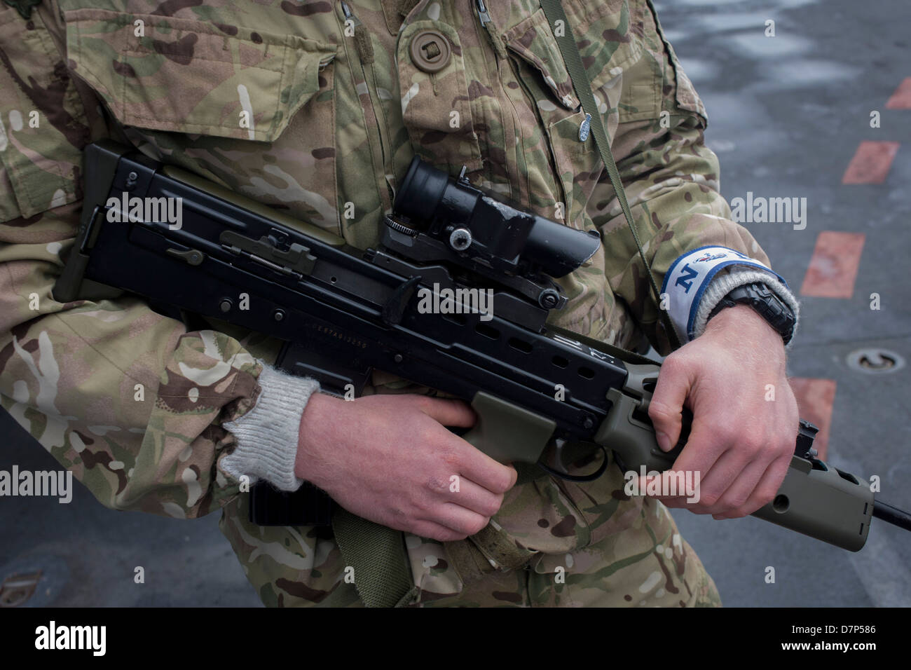 A detail of the arms of a Royal Marines Commando guarding the top deck ...