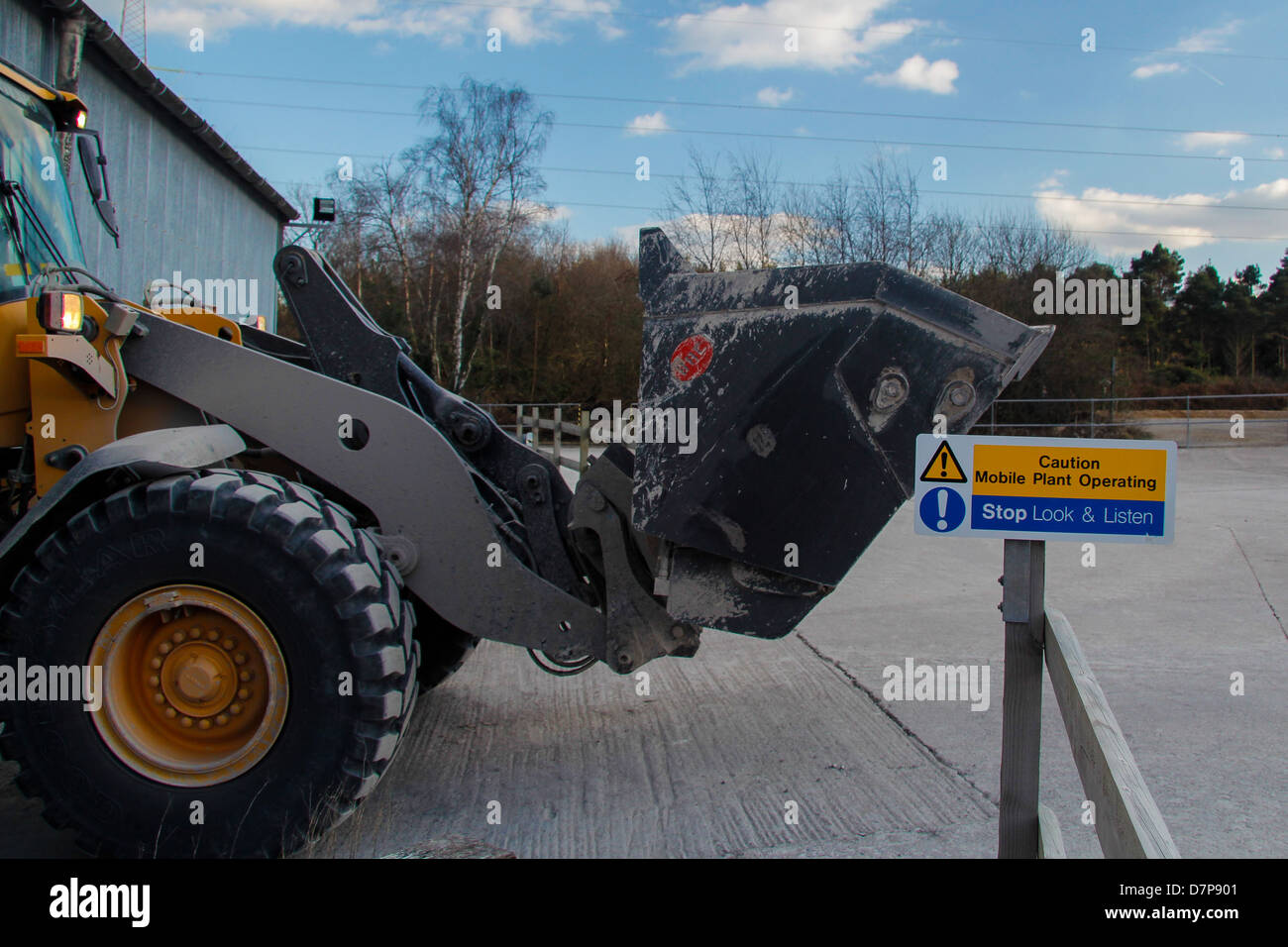 A front end loading shovel exiting an industrial building doorway Stock ...