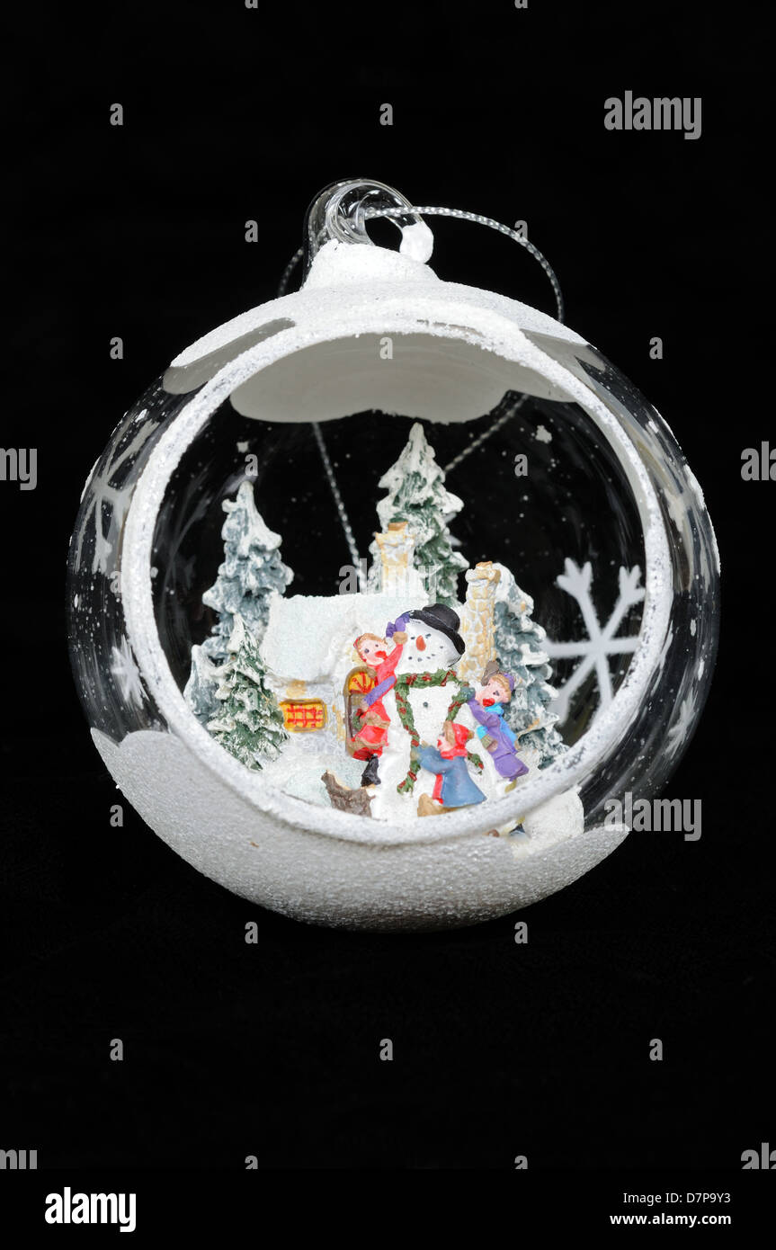 Clear glass Christmas bauble with Winter scene inside against a black ...