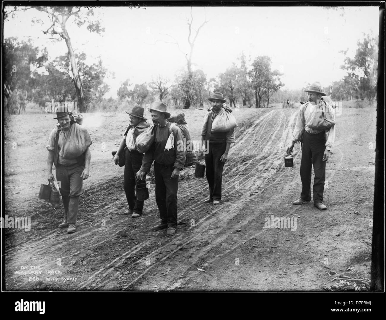 A historic photograph by Charles H. Kerry of men walking along the ...