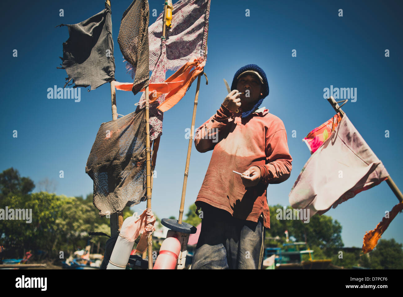 A boat captain lighting up a cigarette, Vietnam Stock Photo - Alamy