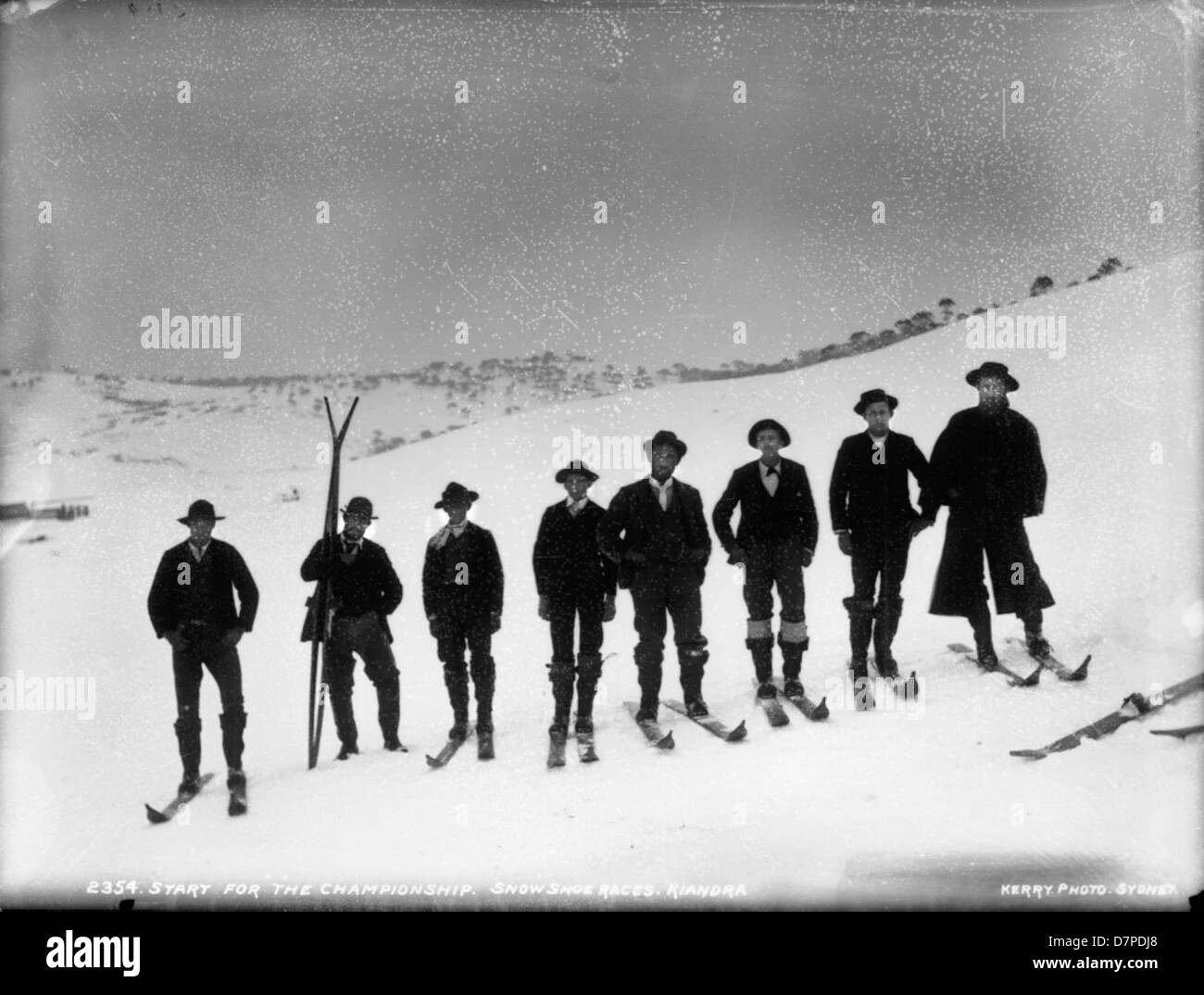 This black-and-white photograph captures a moment from a snowshoe race ...