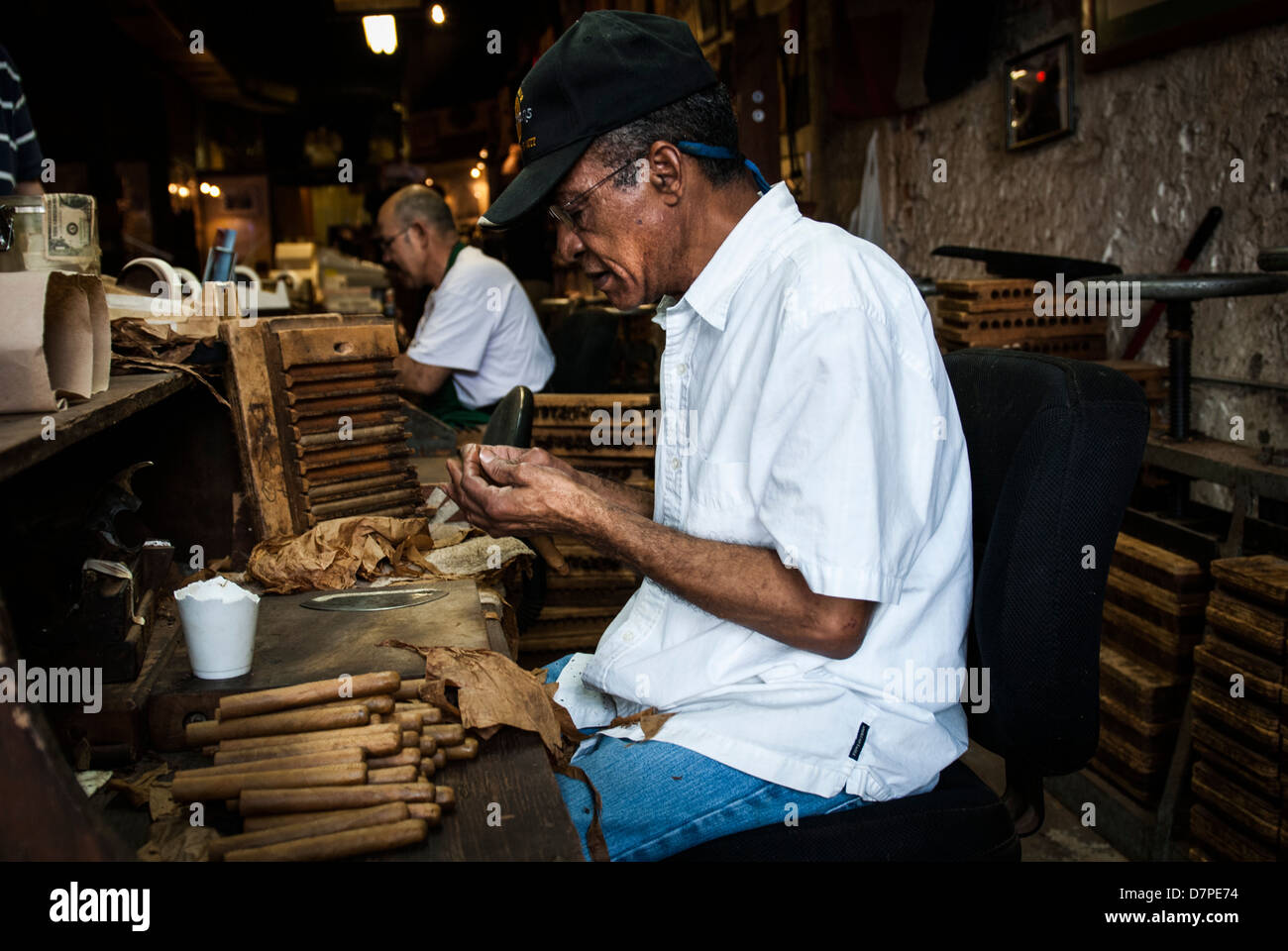 Hispanic men roll cigars in a workshop Stock Photo - Alamy