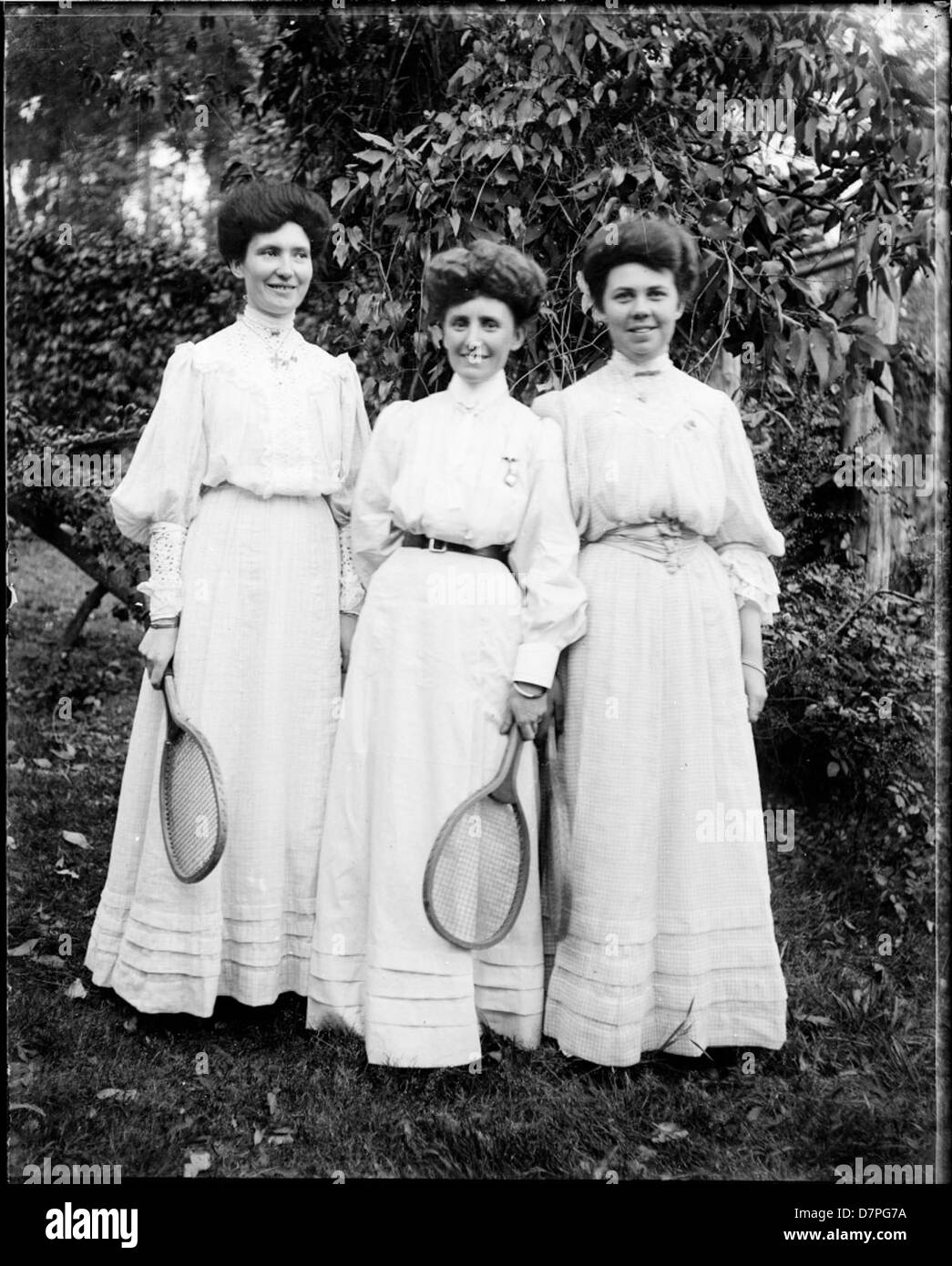 This 1910 photograph features three young women in light dresses ...