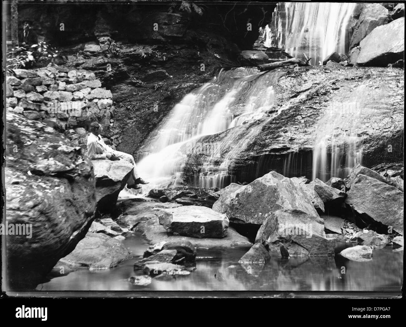View of seated man, waterfall behind Stock Photo - Alamy
