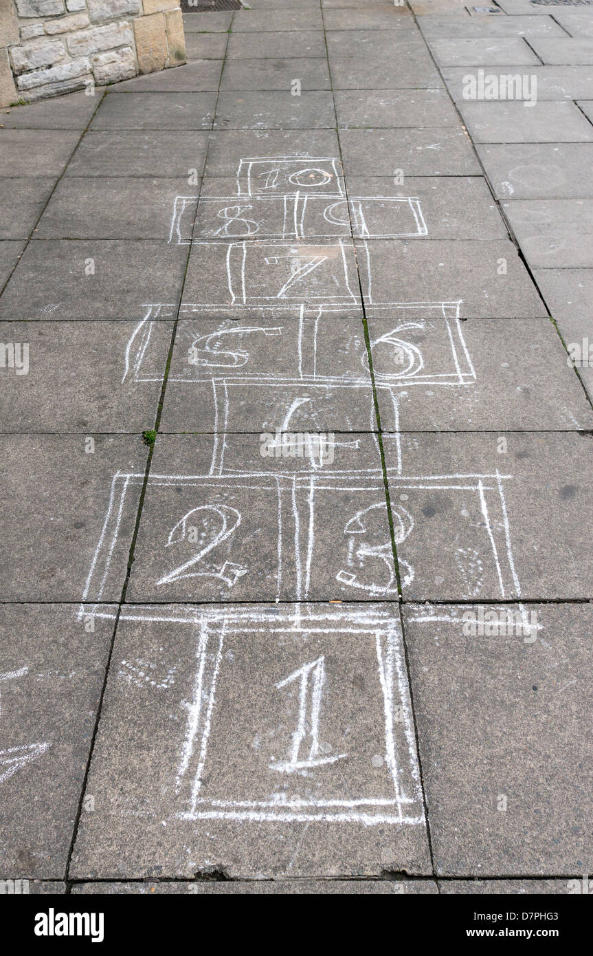 Childrens traditional old fashioned hop scotch game grid drawn in chalk ...