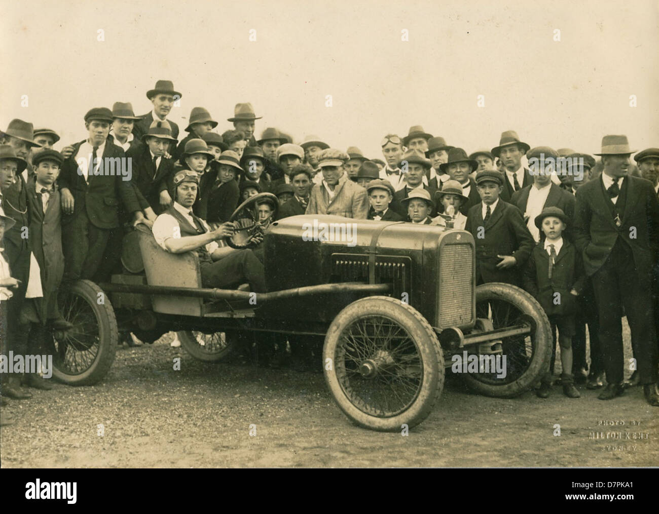 This photograph shows a man seated in a modified Overland racing car ...