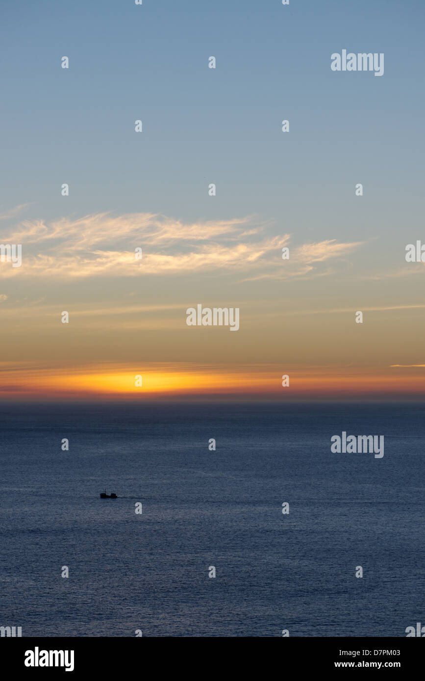 Sunset over the ocean with boat Stock Photo - Alamy