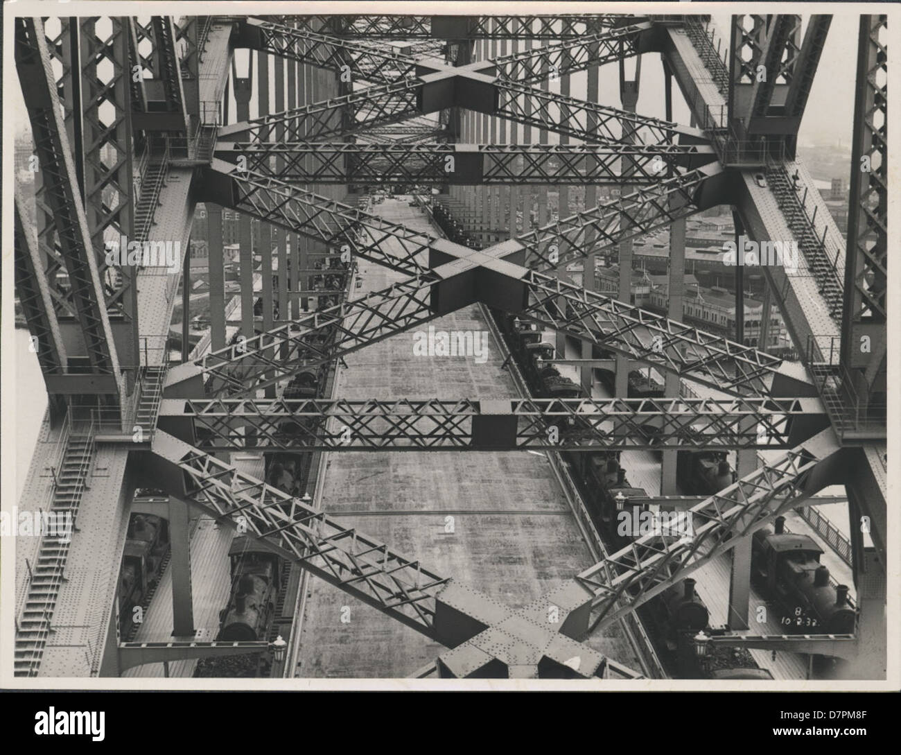 The Sydney Harbour Bridge, under construction, displays workers engaged ...