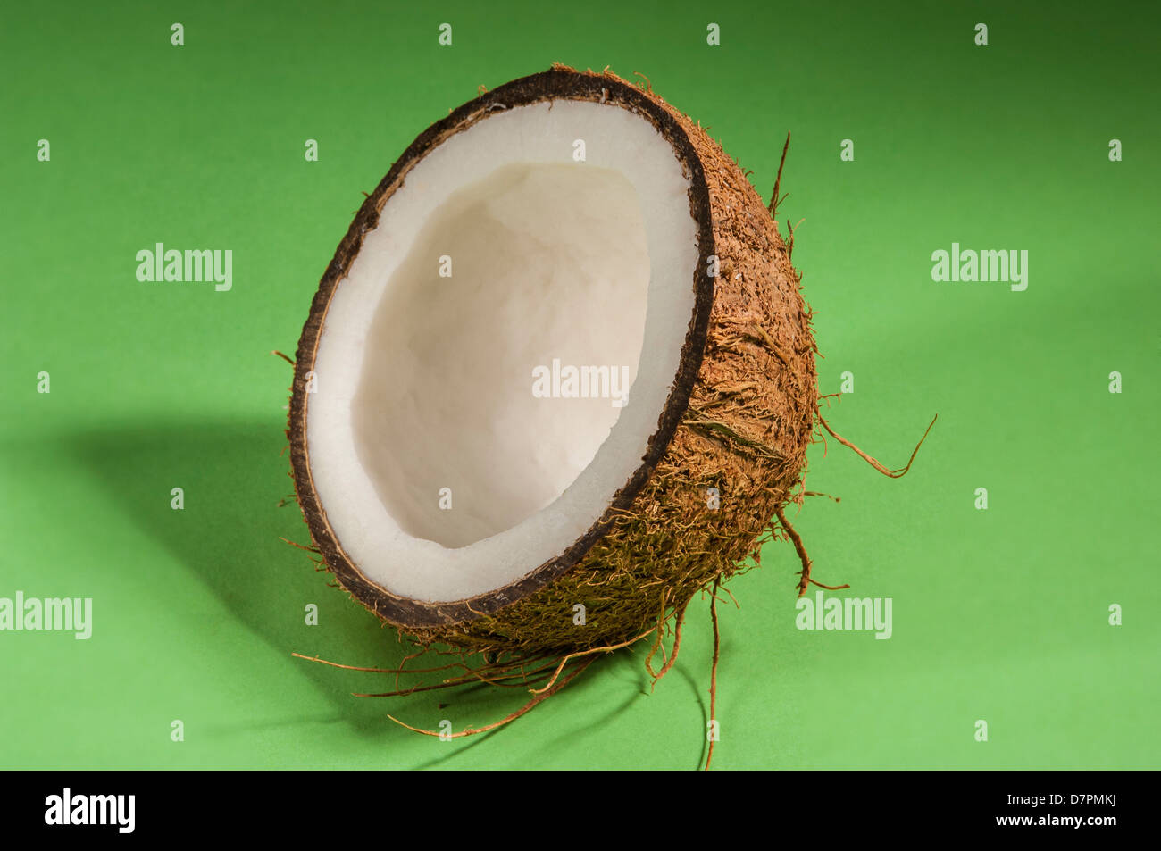 Half a coconut on green background Stock Photo - Alamy