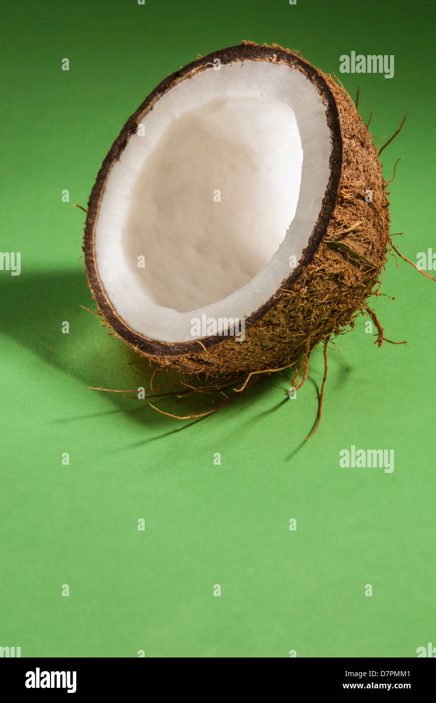 Studio shot of half a coconut on green background Stock Photo - Alamy