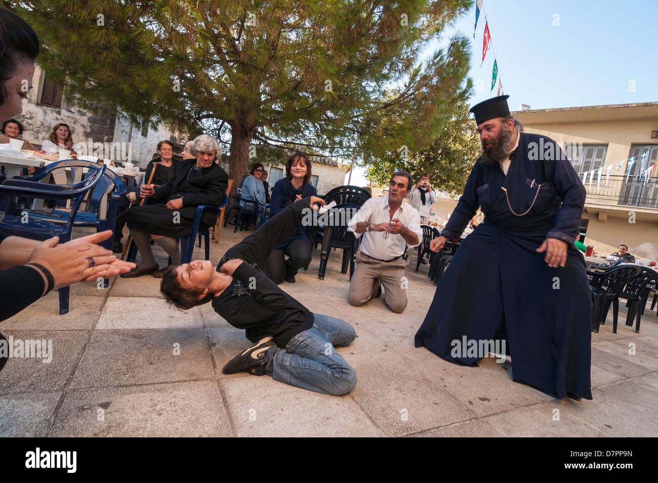Greek boy and priest dancing at a Panayiri, a village festival in ...