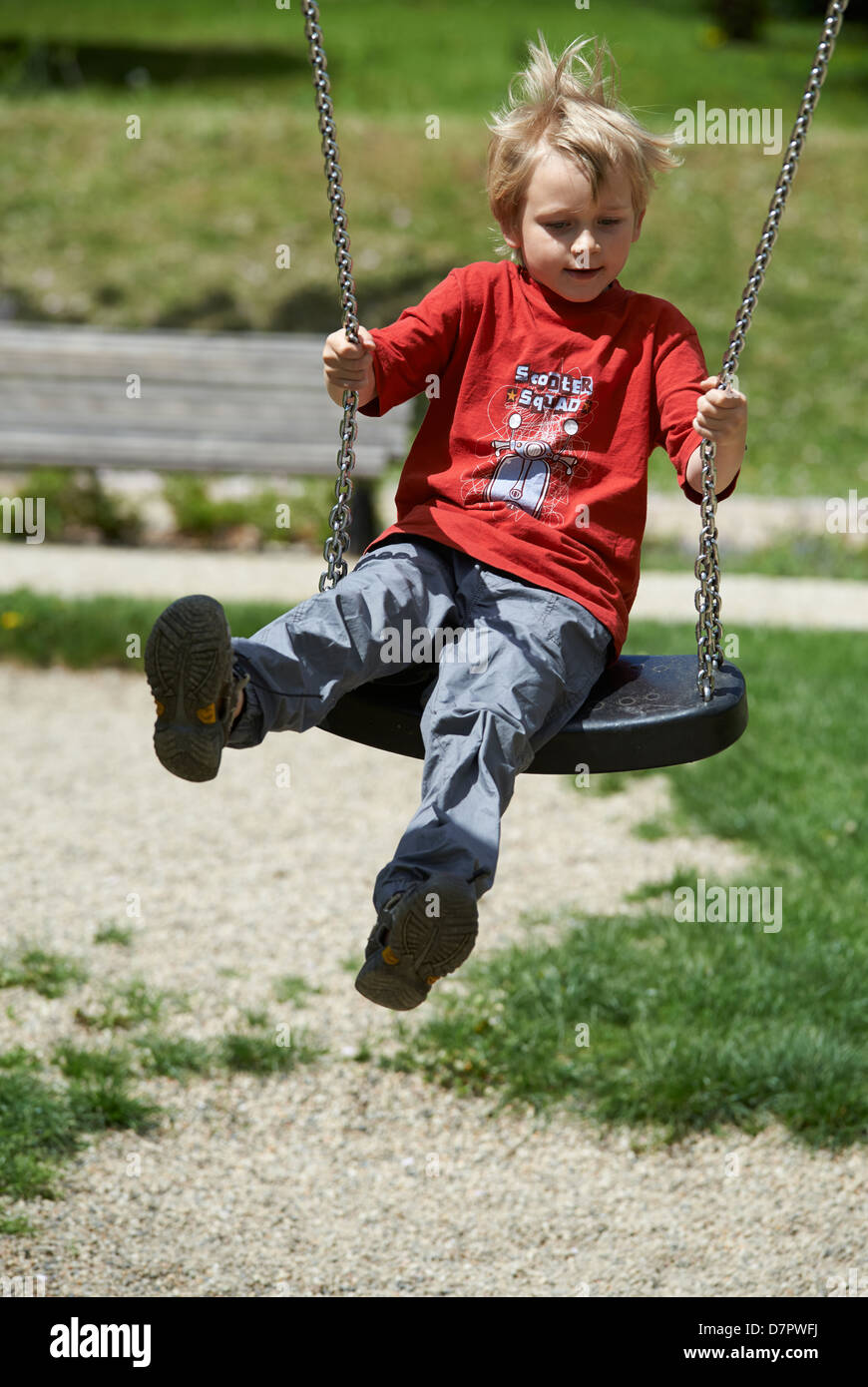 Blond child boy kid having fun on a swing, summertime, playground Stock ...