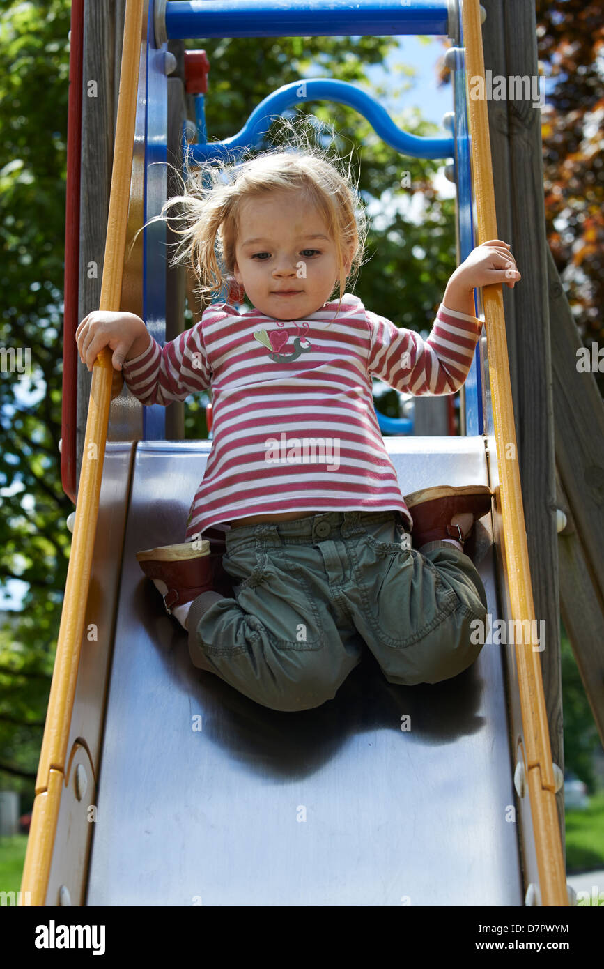 Child Blond Girl sliding slide on a playground Stock Photo - Alamy