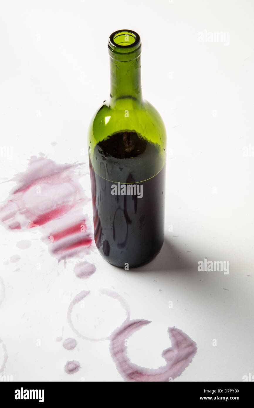 Red wine bottle, partially empty with wine stains around it Stock Photo ...