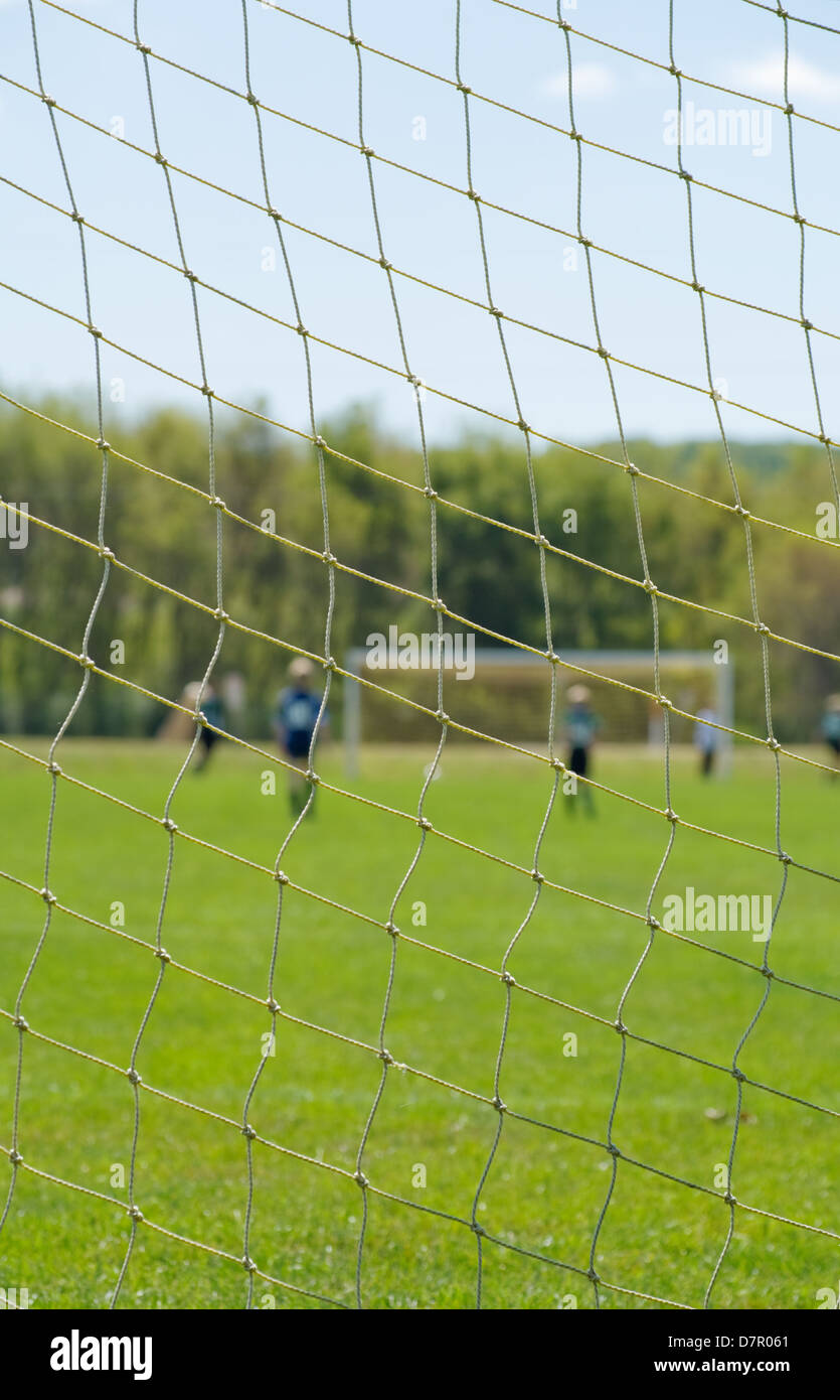 Football net with players in background Stock Photo - Alamy