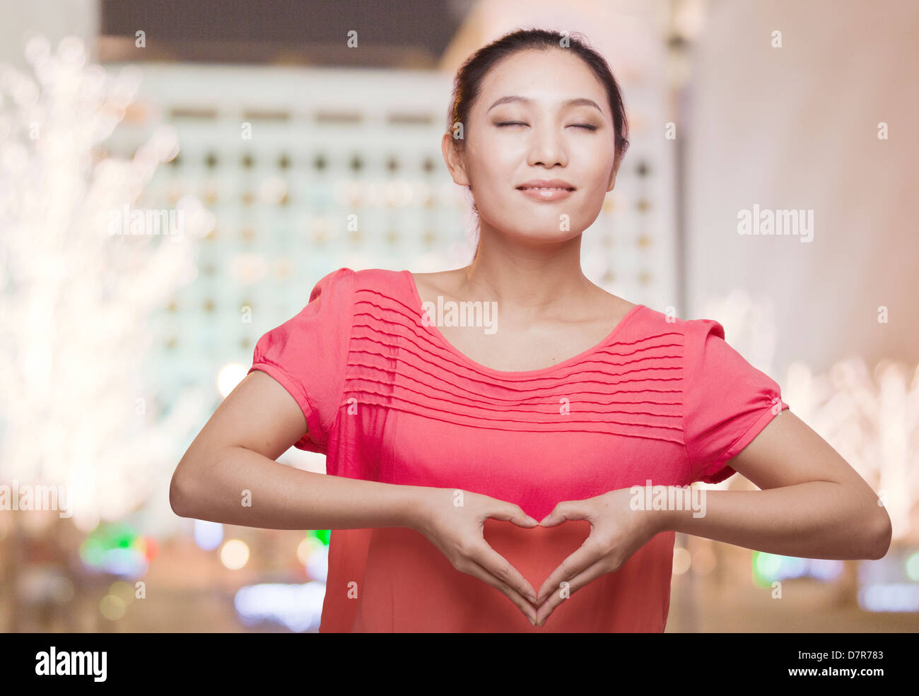 Young Woman Making Heart Sign with Hands Stock Photo - Alamy