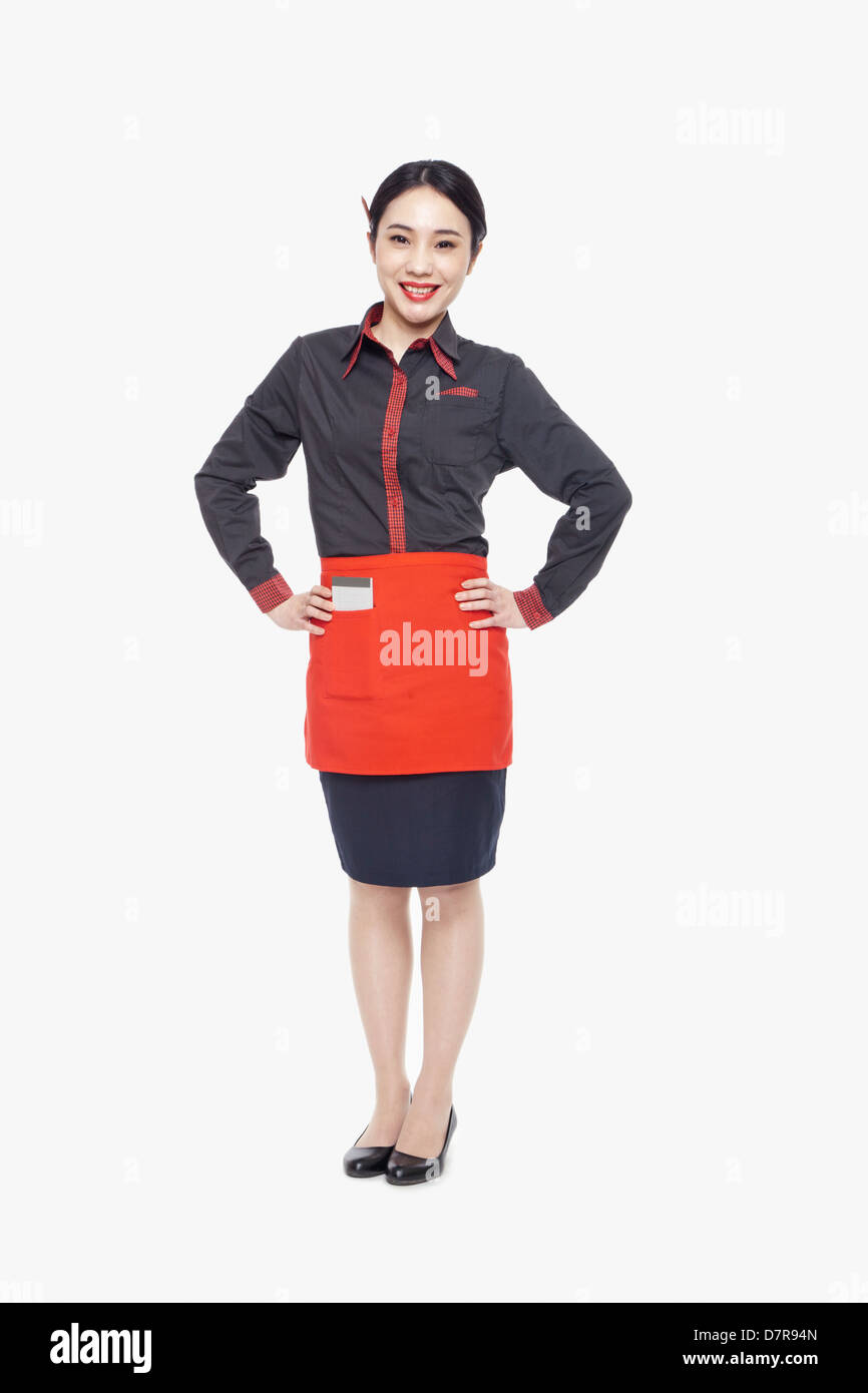 Young waitress, hand on hips, studio shot Stock Photo - Alamy