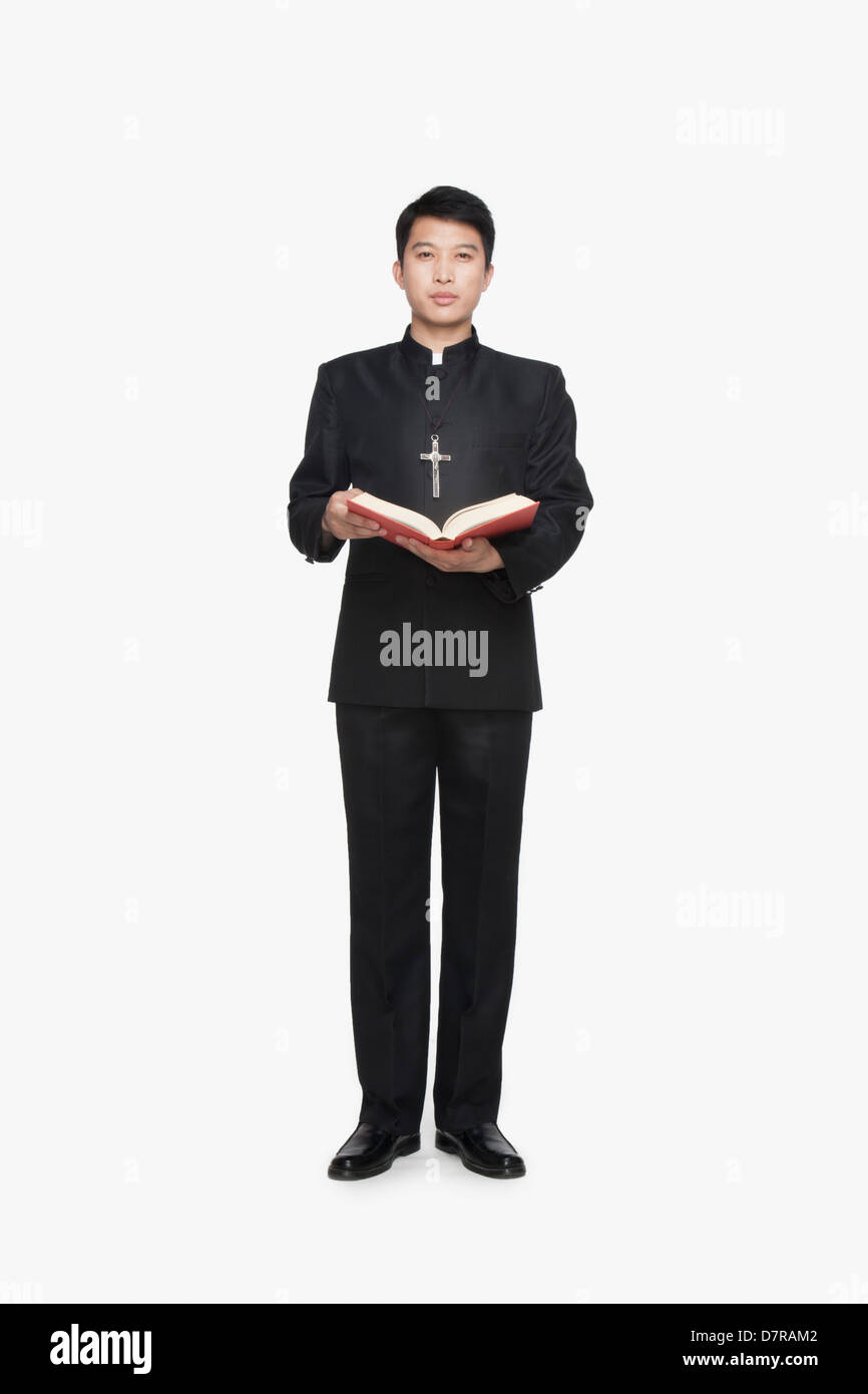 Young Priest Standing with Bible Stock Photo - Alamy