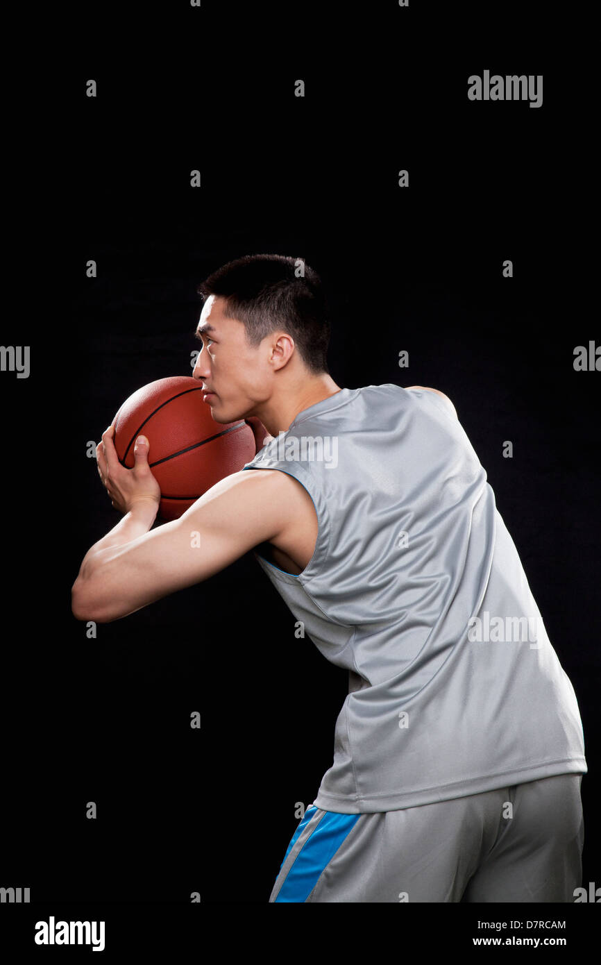 Basketball player ready to throw ball, black background Stock Photo - Alamy