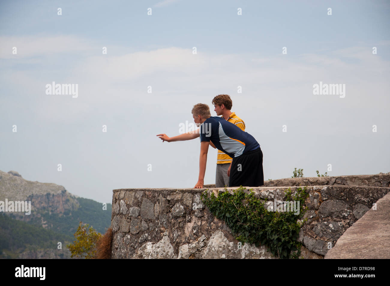 Two young men with a view of a mountain landscape Stock Photo - Alamy