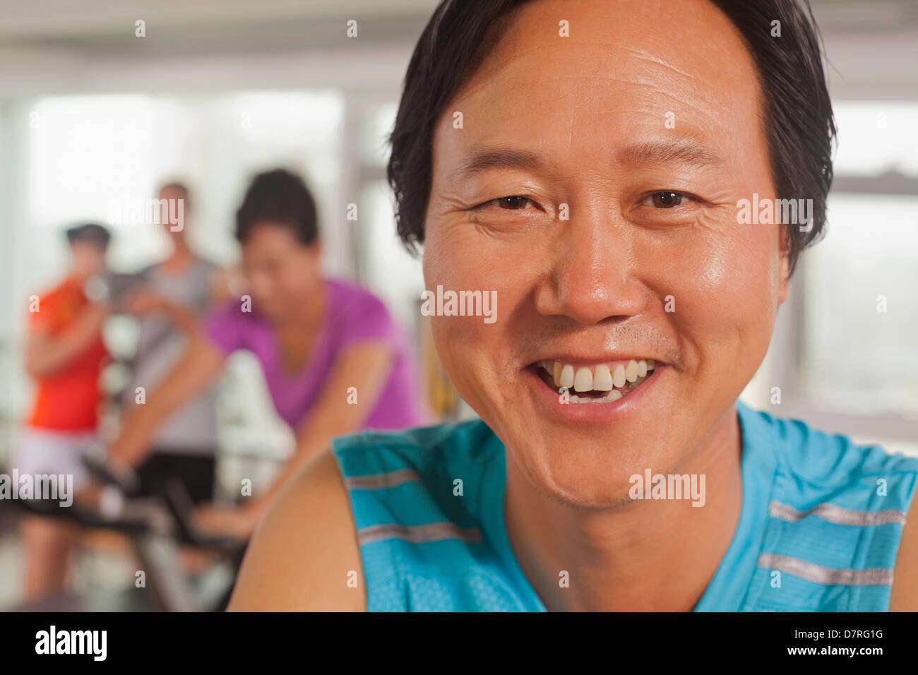 Man smiling and exercising on the exercise bike Stock Photo - Alamy
