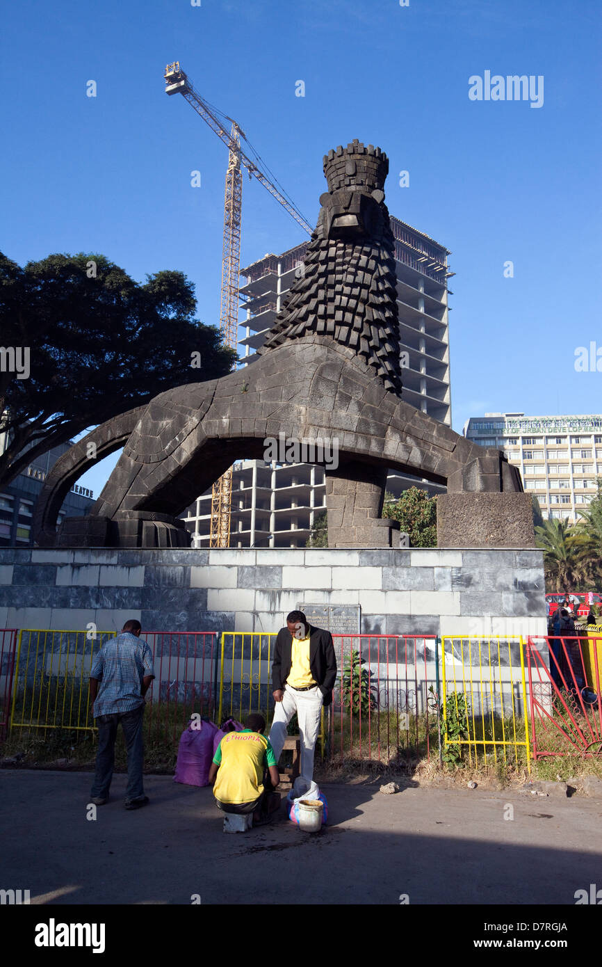A man has his shoes shined beneath a Lion of Judah statue outside the ...