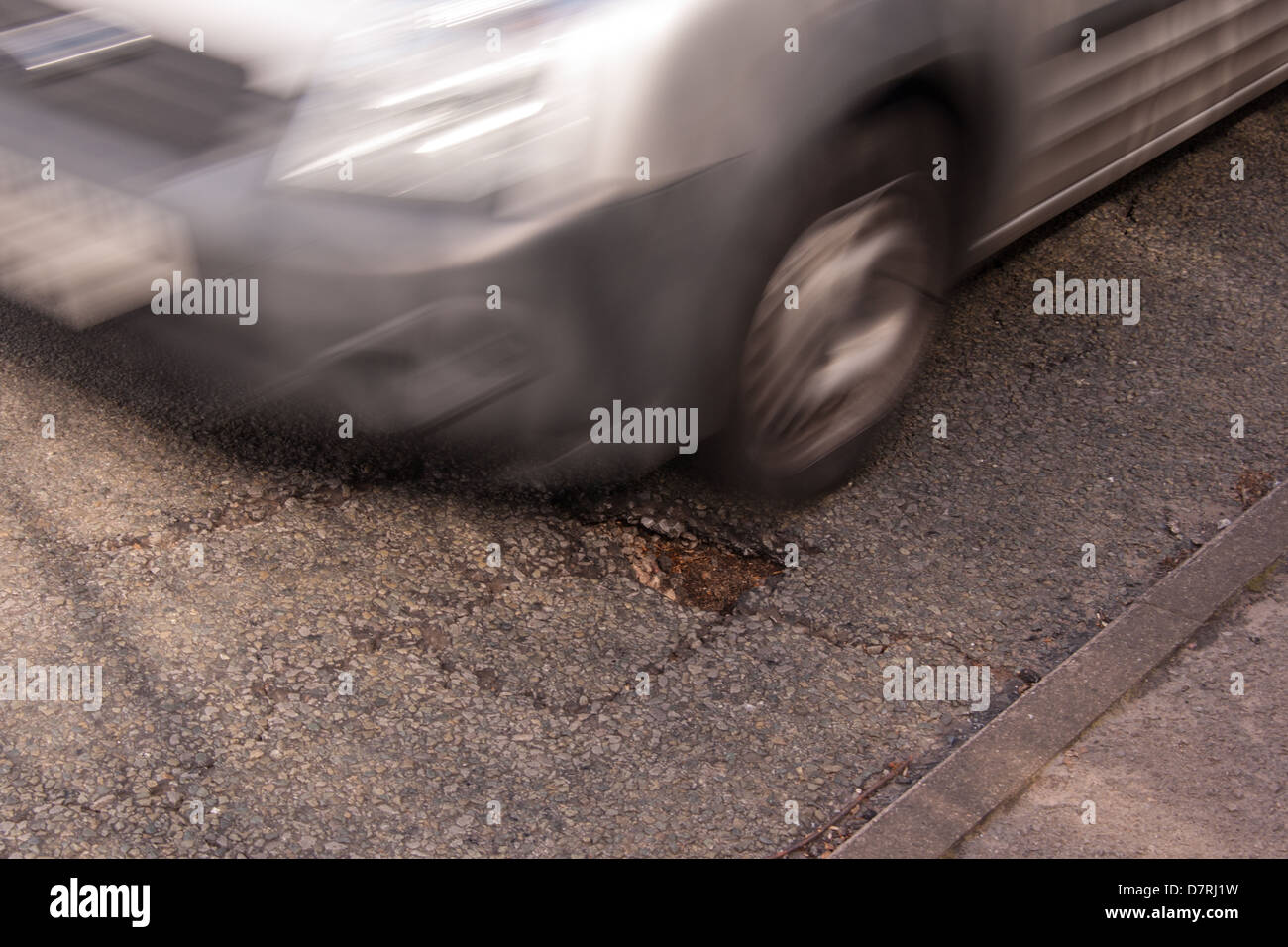 Car about to hit a pothole which is due to poor maintenance, road ...