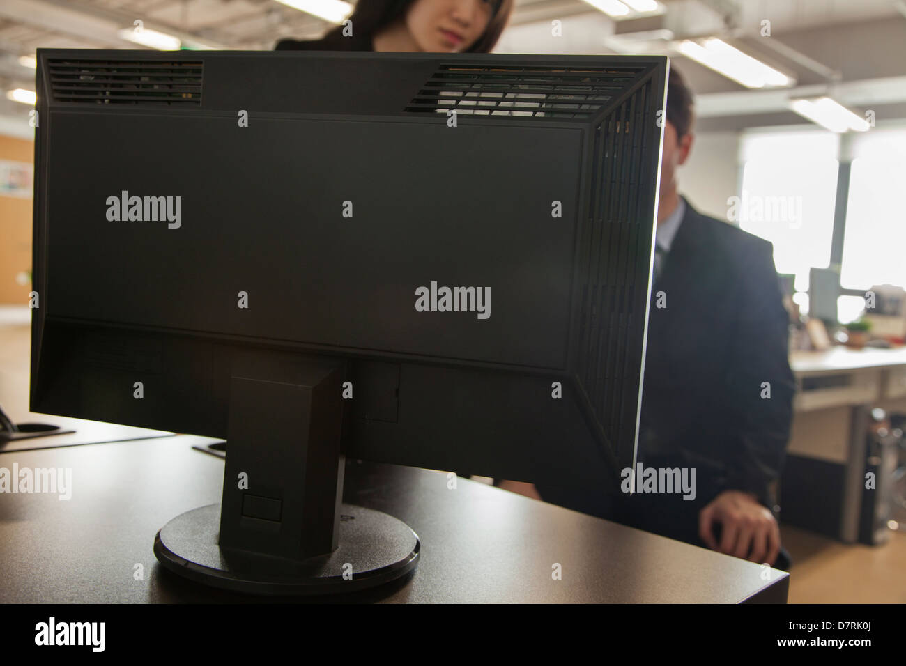 Two coworkers looking at computer monitor Stock Photo - Alamy