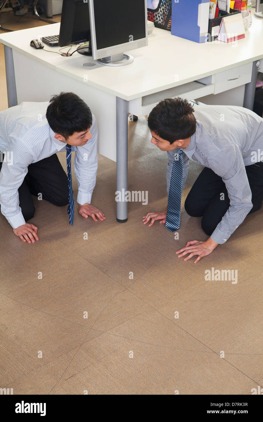 Two businessmen crouching on the floor Stock Photo - Alamy