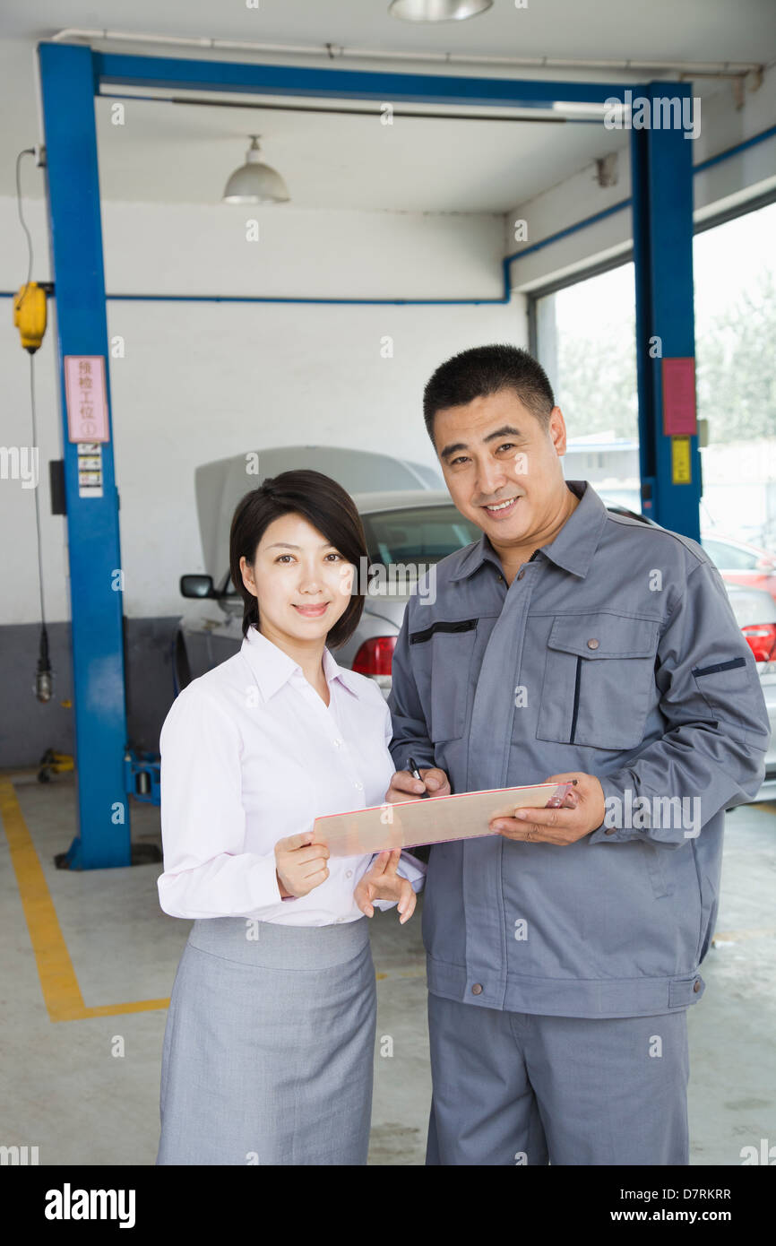 Garage Mechanic Explaining to Customer Stock Photo - Alamy