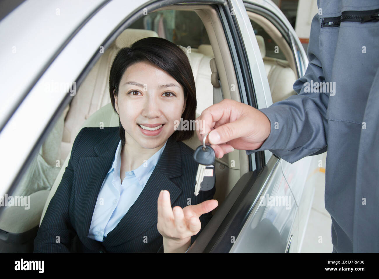 Mechanic Handing Keys to Businesswoman Stock Photo - Alamy